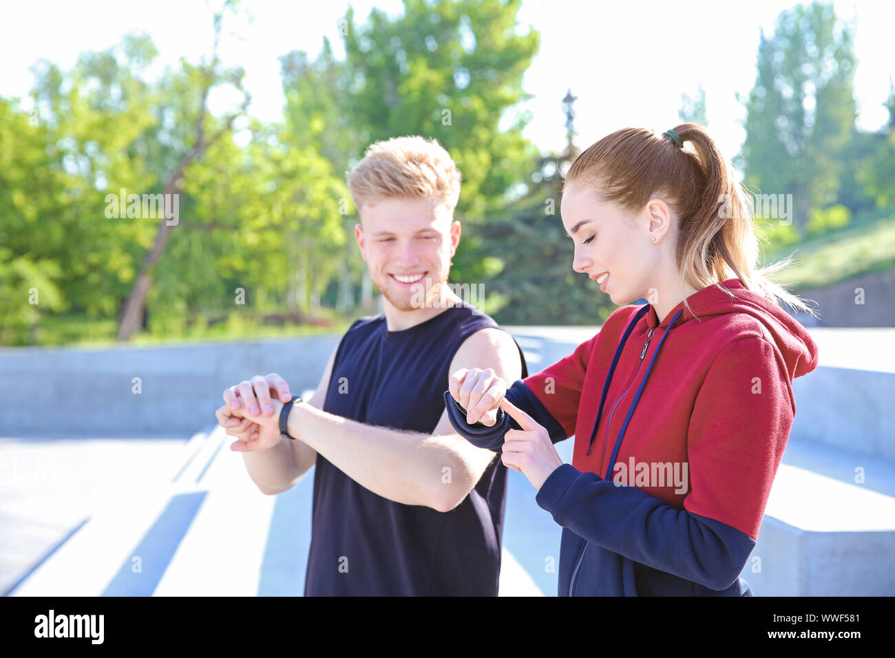 Sporty young people checking their pulse outdoors Stock Photo - Alamy