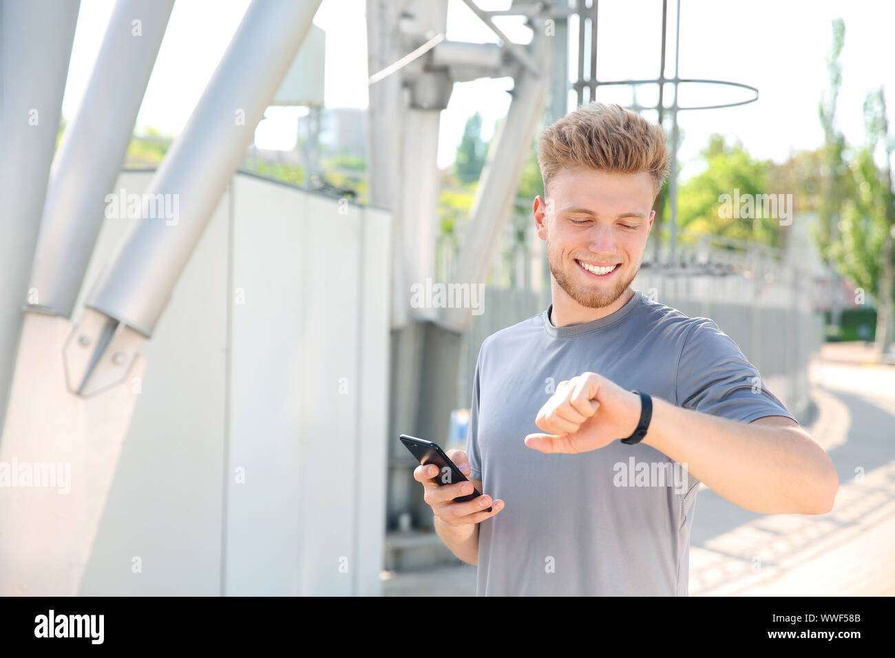 Sporty young man checking his pulse outdoors Stock Photo - Alamy
