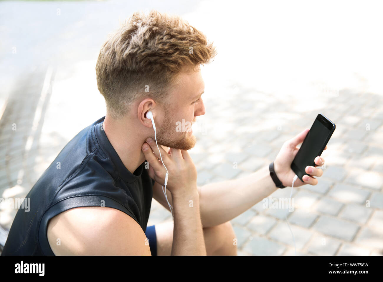 Sporty young man checking his pulse outdoors Stock Photo - Alamy