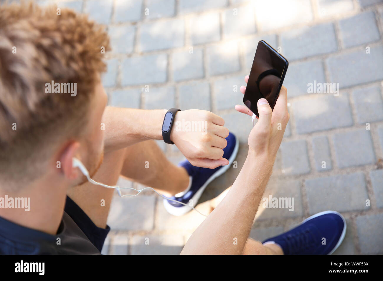 Sporty young man checking his pulse outdoors Stock Photo - Alamy