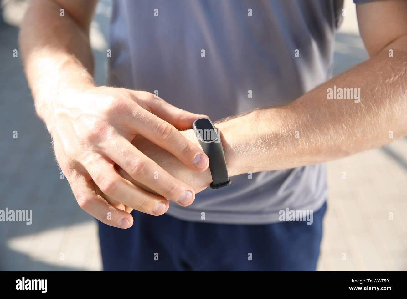 Sporty young man checking his pulse outdoors, closeup Stock Photo - Alamy