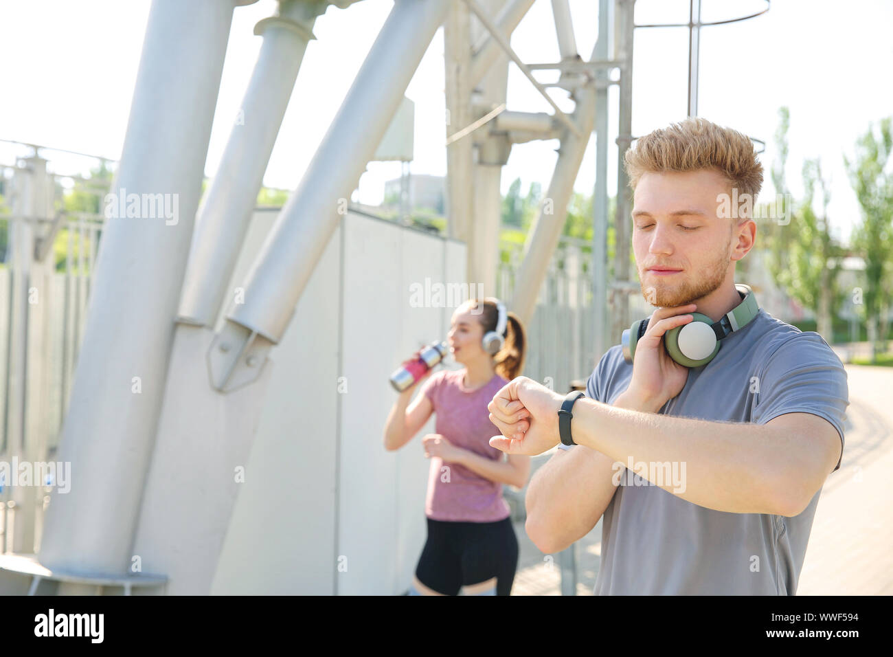Sporty young man checking his pulse outdoors Stock Photo - Alamy