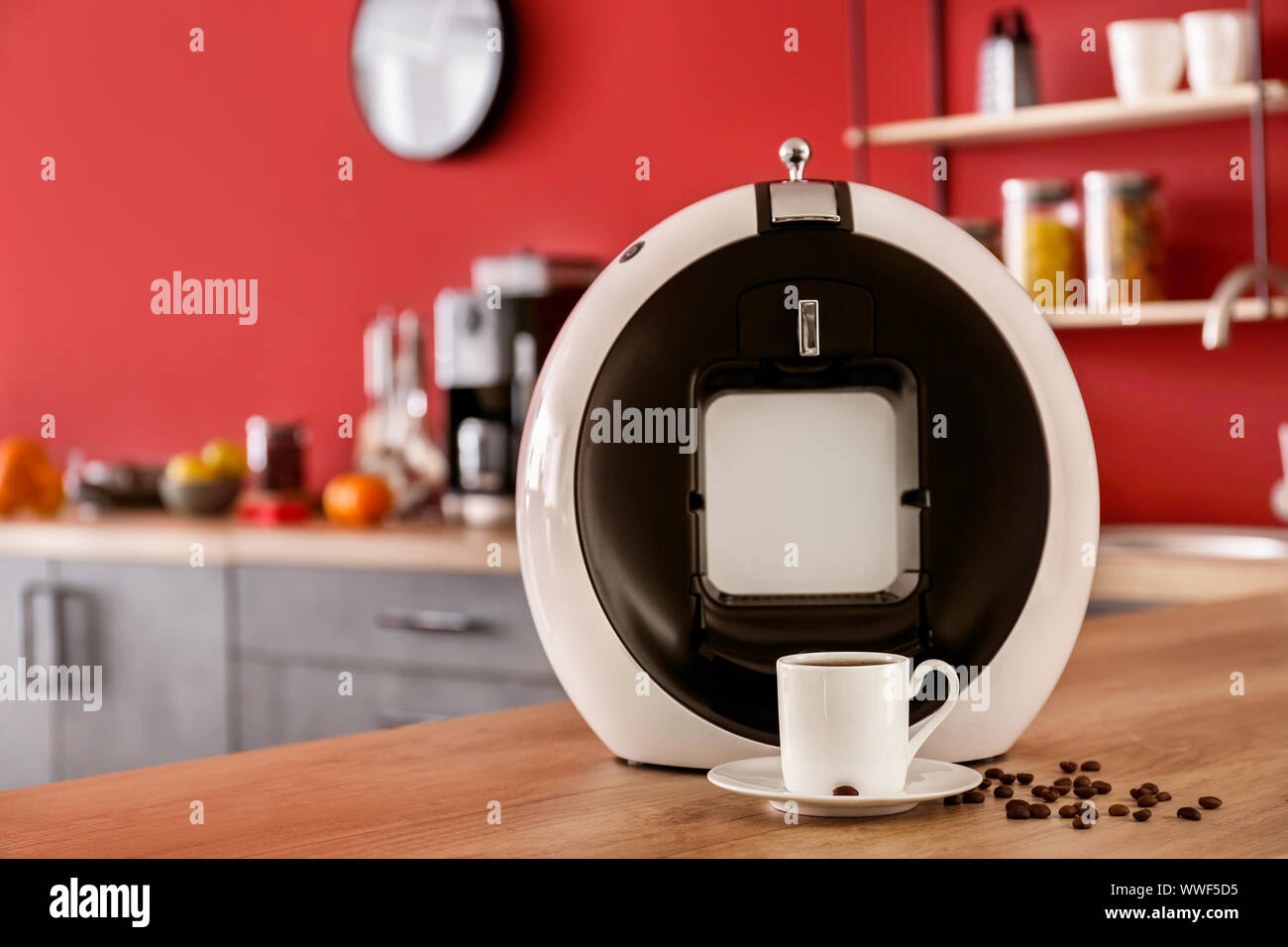 Modern coffee maker with cup on table in kitchen Stock Photo - Alamy