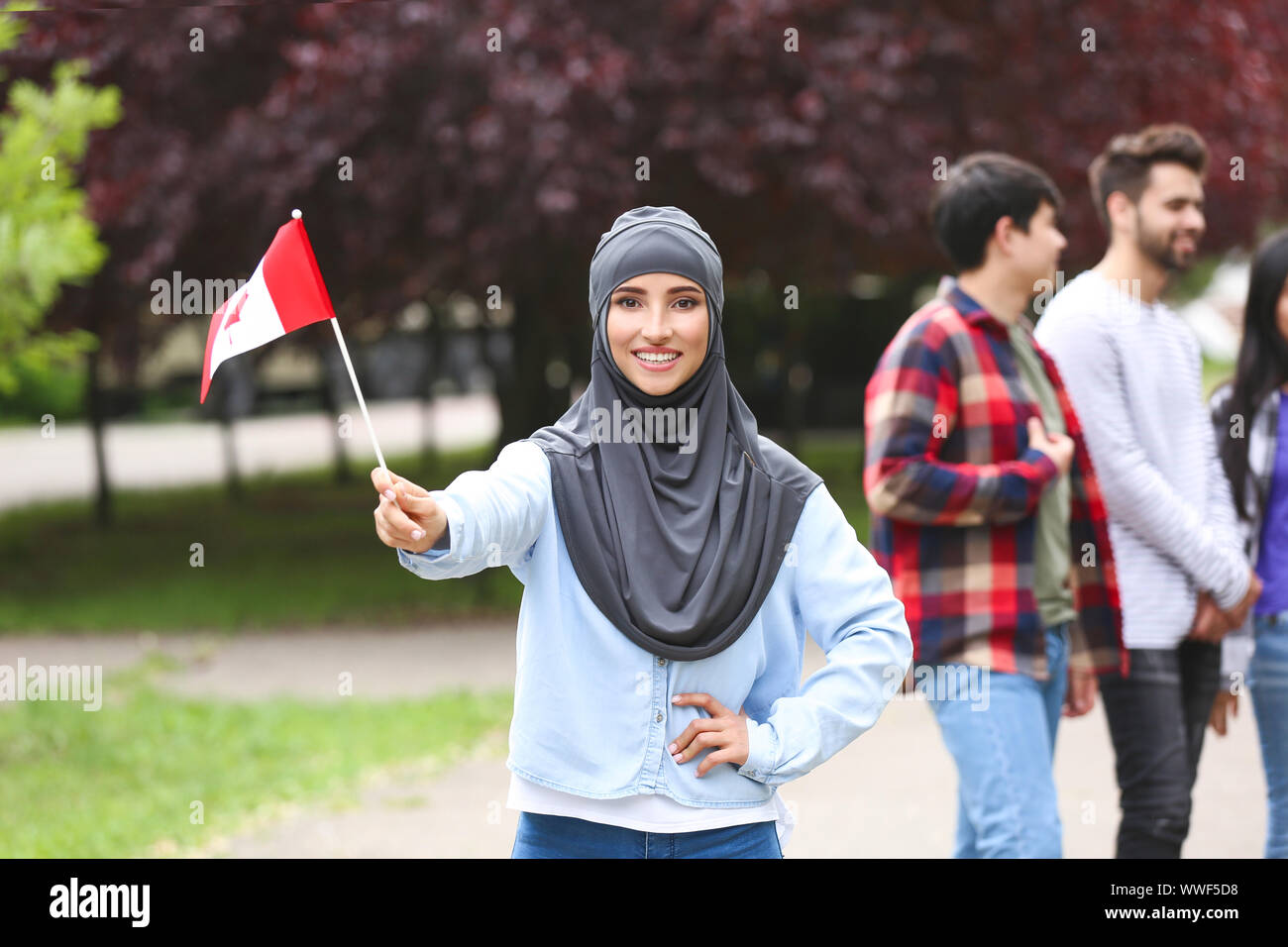 Female Muslim student with Canadian flag outdoors Stock Photo - Alamy