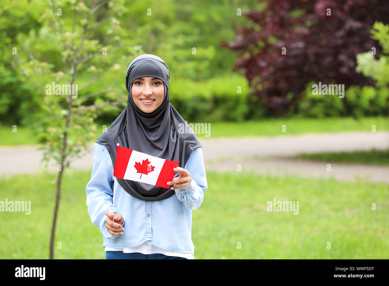 Female Muslim student with Canadian flag outdoors Stock Photo - Alamy