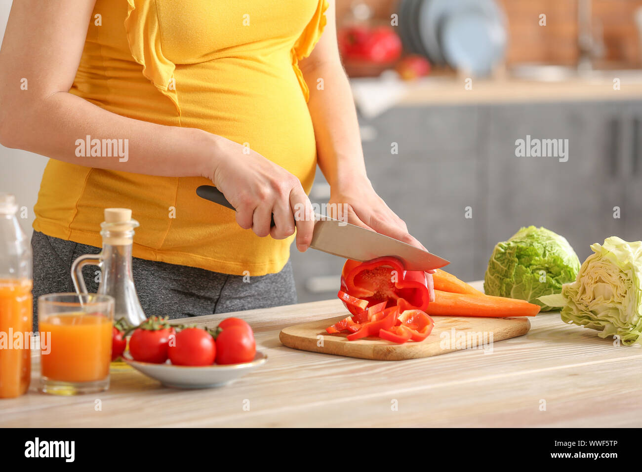 Young pregnant woman cooking in kitchen Stock Photo - Alamy