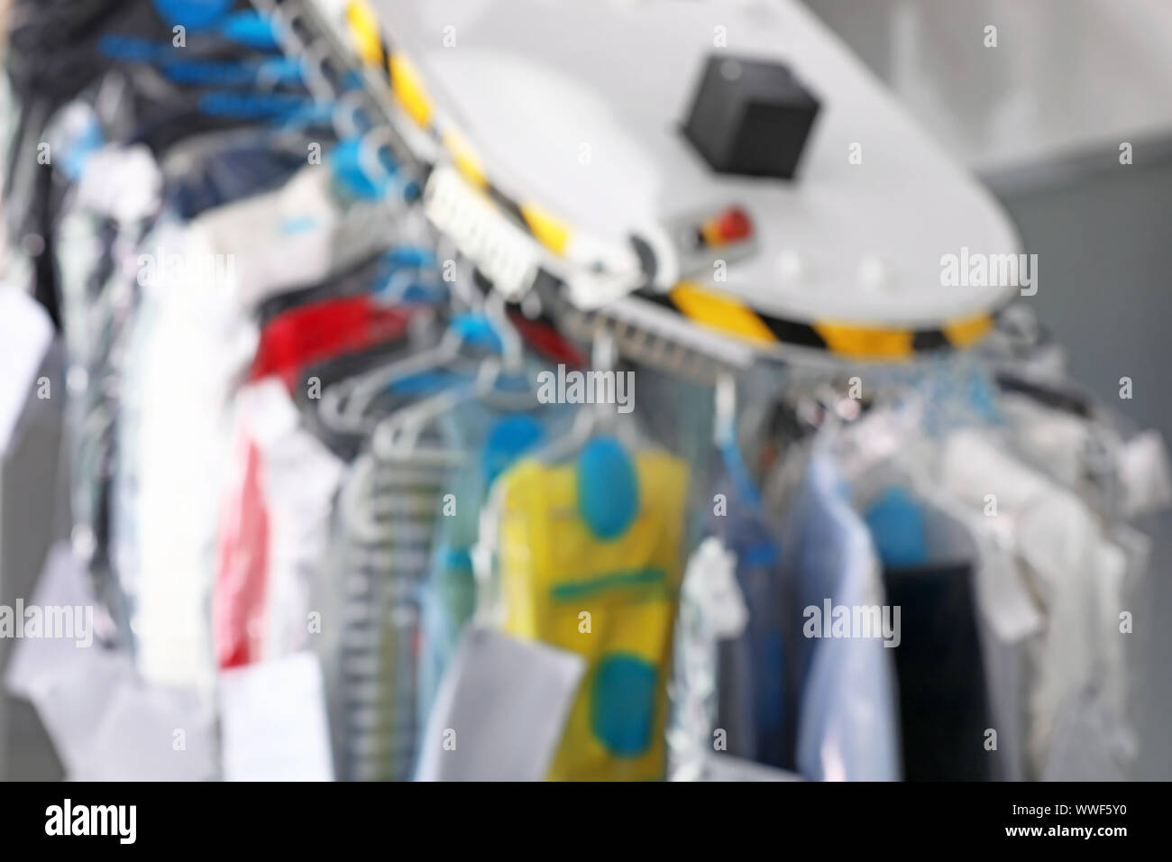 Rack with clothes in modern dry-cleaner's, blurred view Stock Photo - Alamy