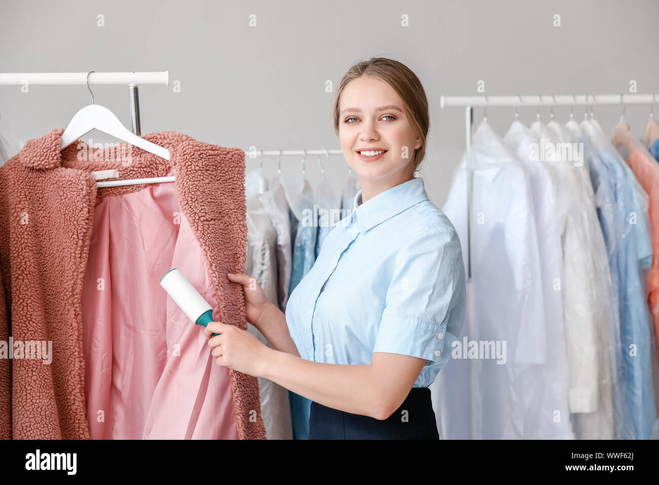 Woman removing dirt from clothes in modern dry-cleaner's Stock Photo ...