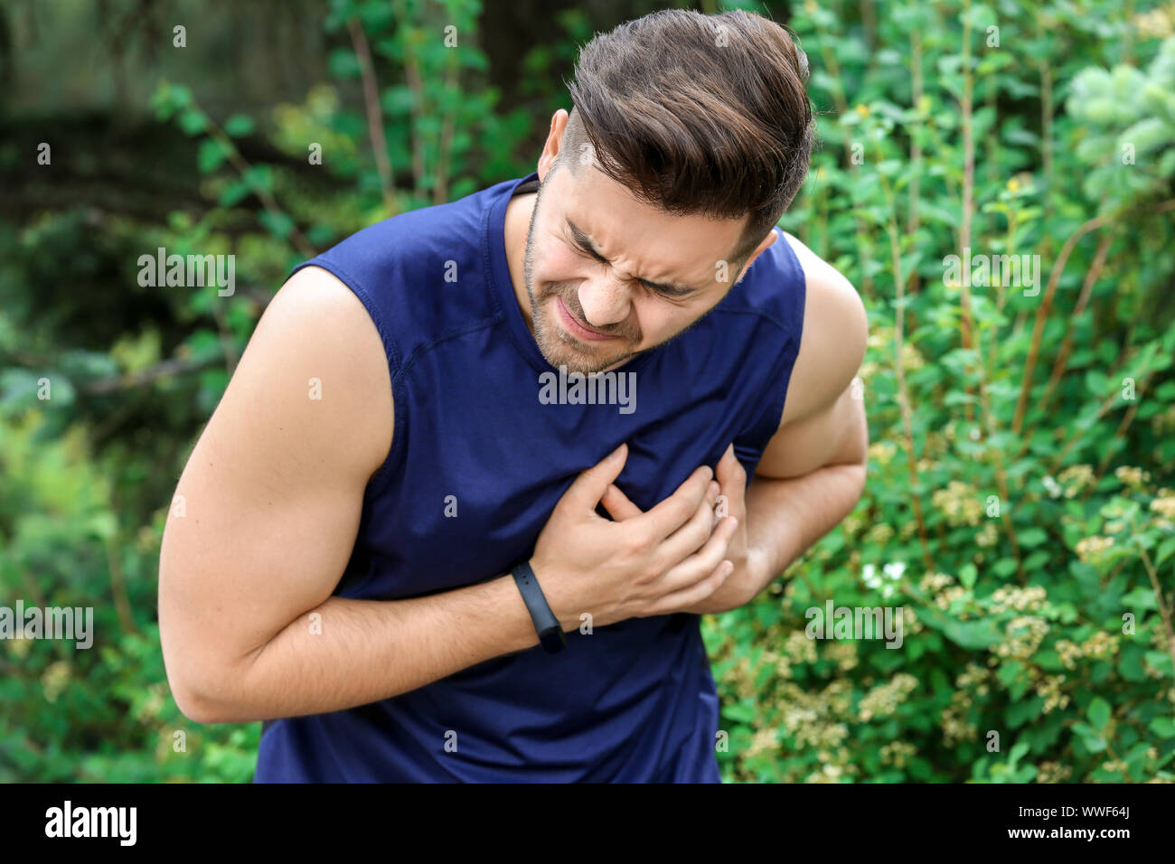 Sporty young man suffering from heart attack outdoors Stock Photo - Alamy