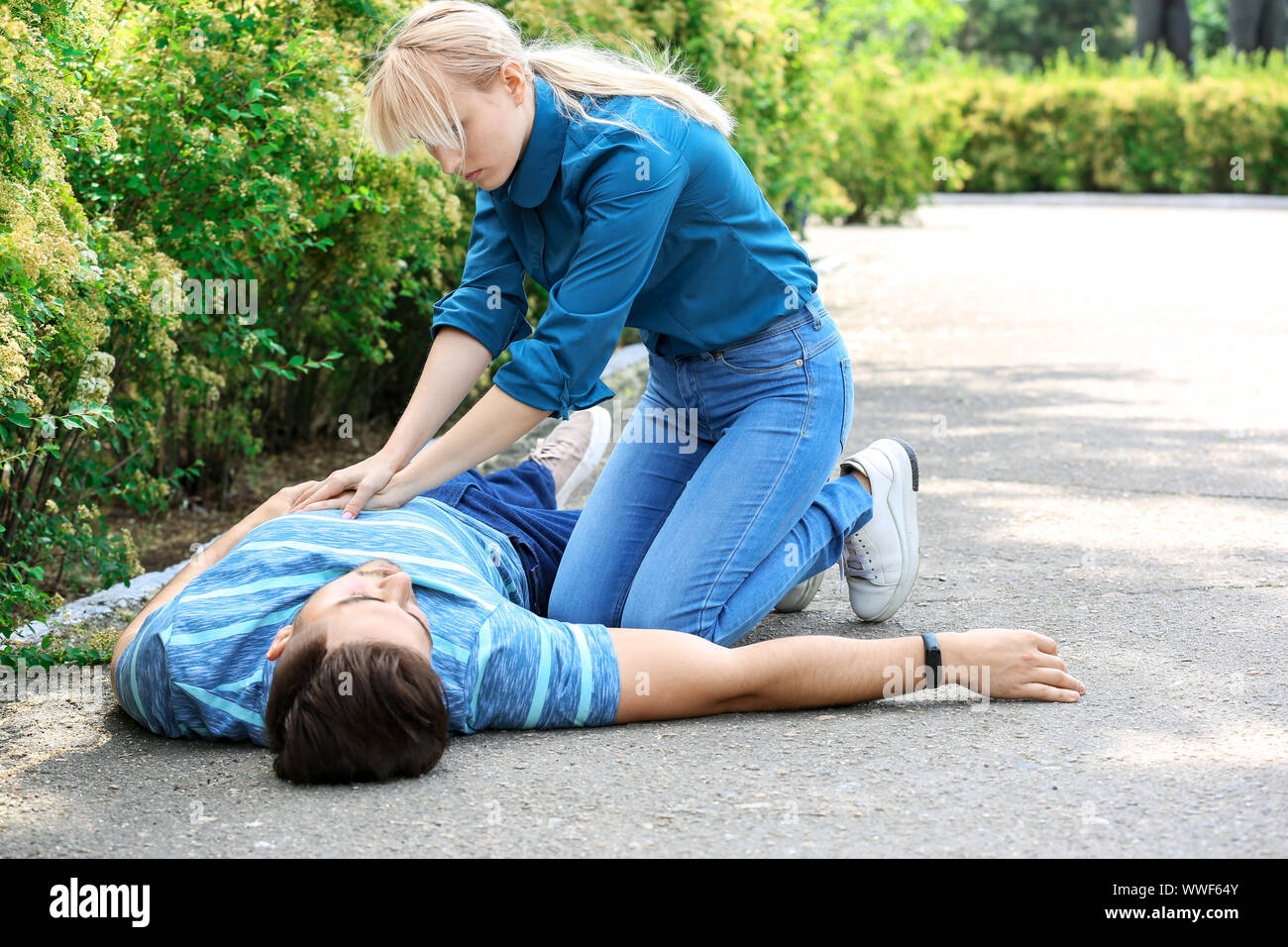 Woman giving CPR to unconscious man outdoors Stock Photo - Alamy