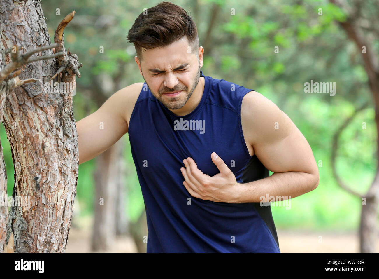 Sporty young man suffering from heart attack outdoors Stock Photo - Alamy