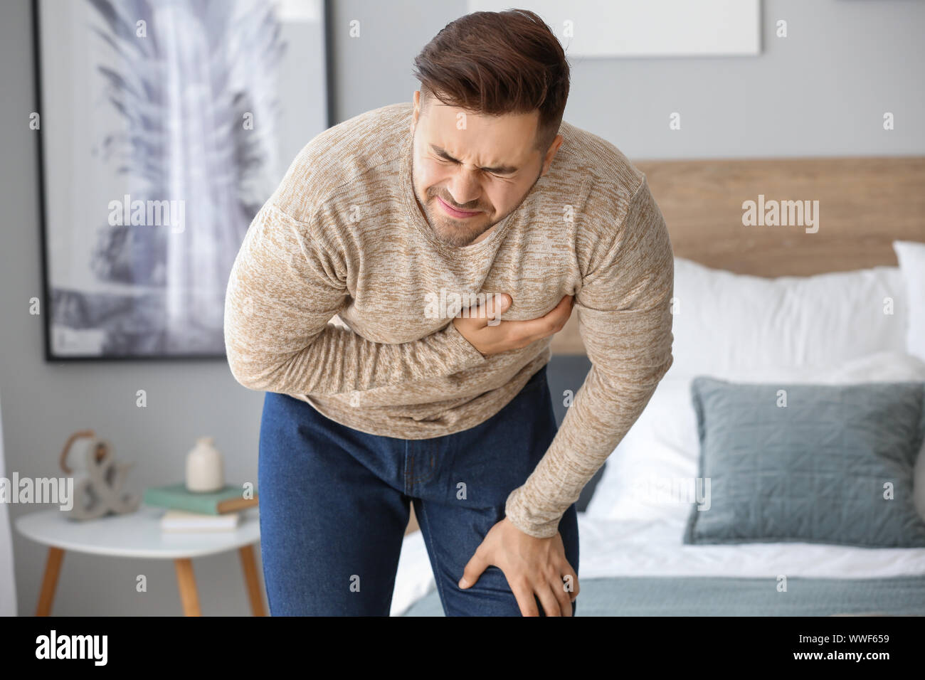 Young man suffering from heart attack at home Stock Photo - Alamy