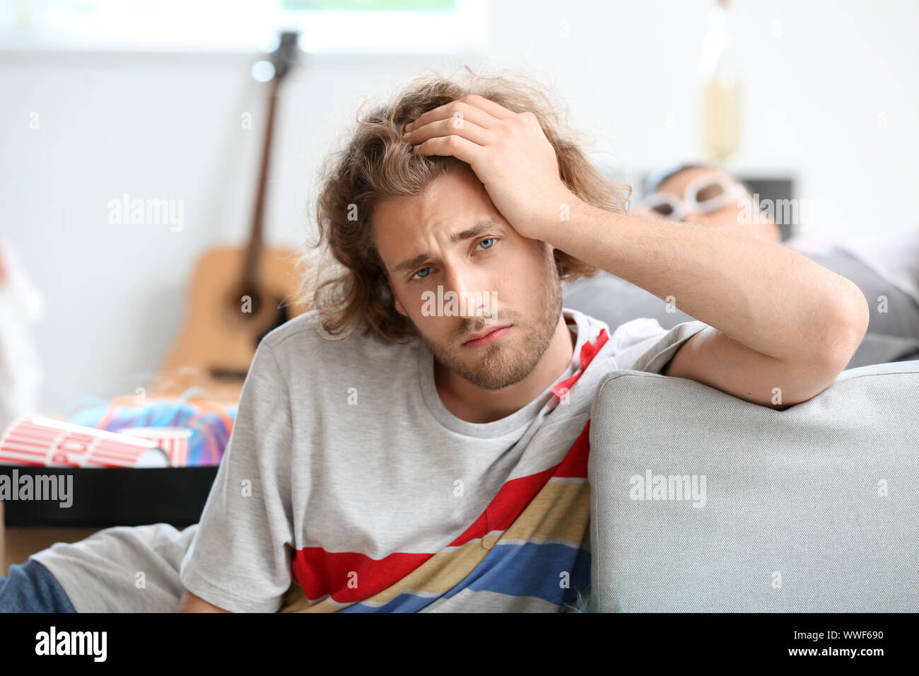 Young man with hangover after party at home Stock Photo - Alamy