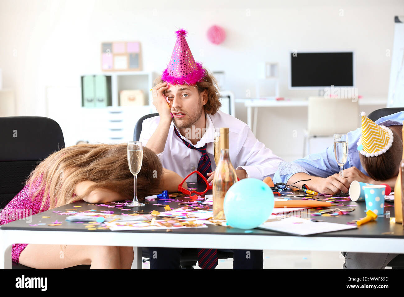 Young people with hangover in office Stock Photo - Alamy