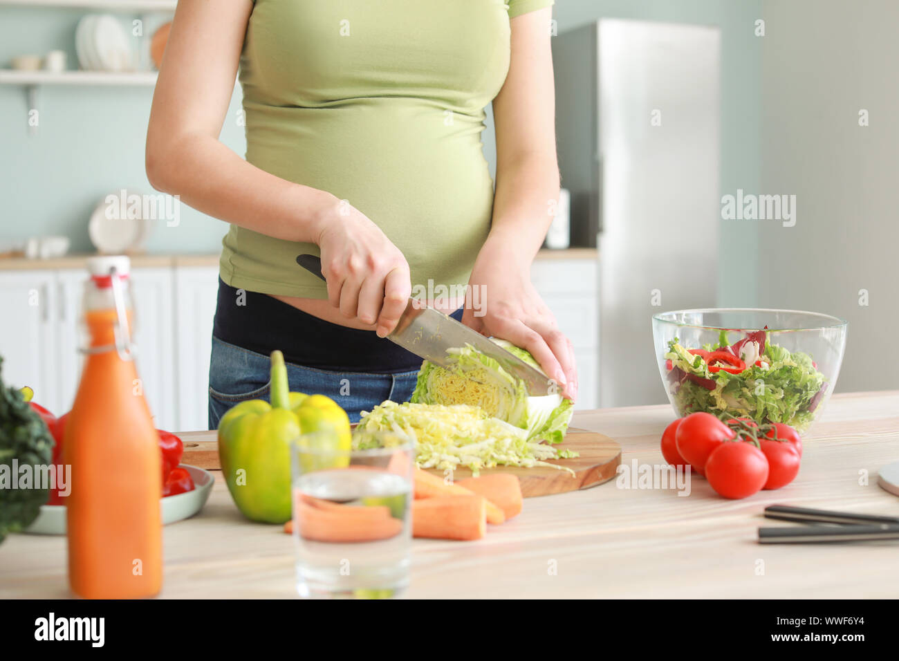 Young pregnant woman cooking in kitchen Stock Photo - Alamy