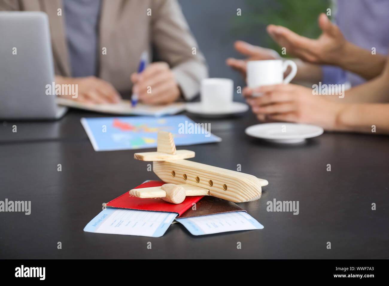 Wooden airplane with passports and tickets on table in travel agency ...