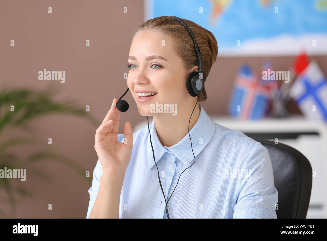 Female travel agent working in office Stock Photo - Alamy