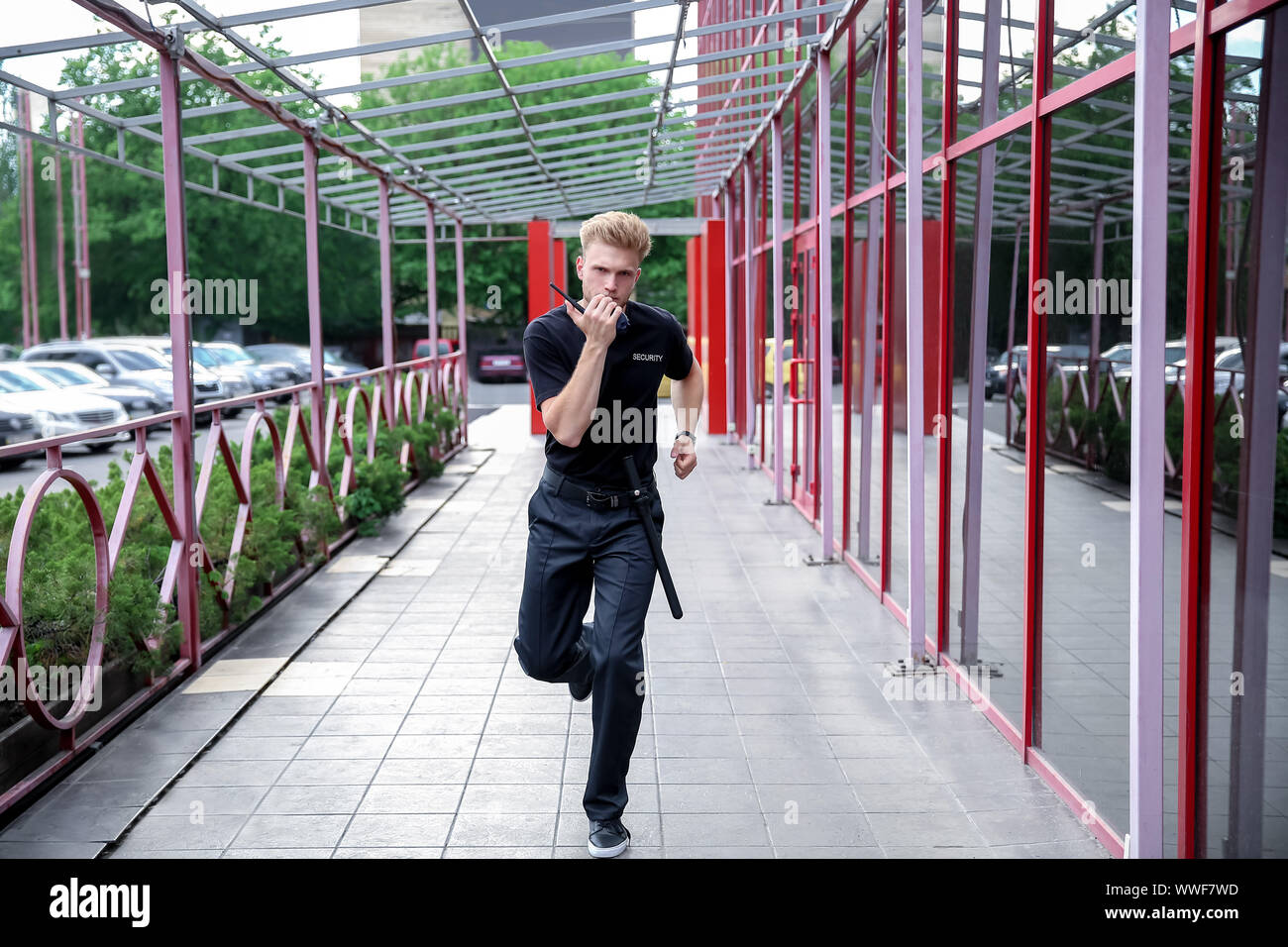 Running male security guard outdoors Stock Photo - Alamy