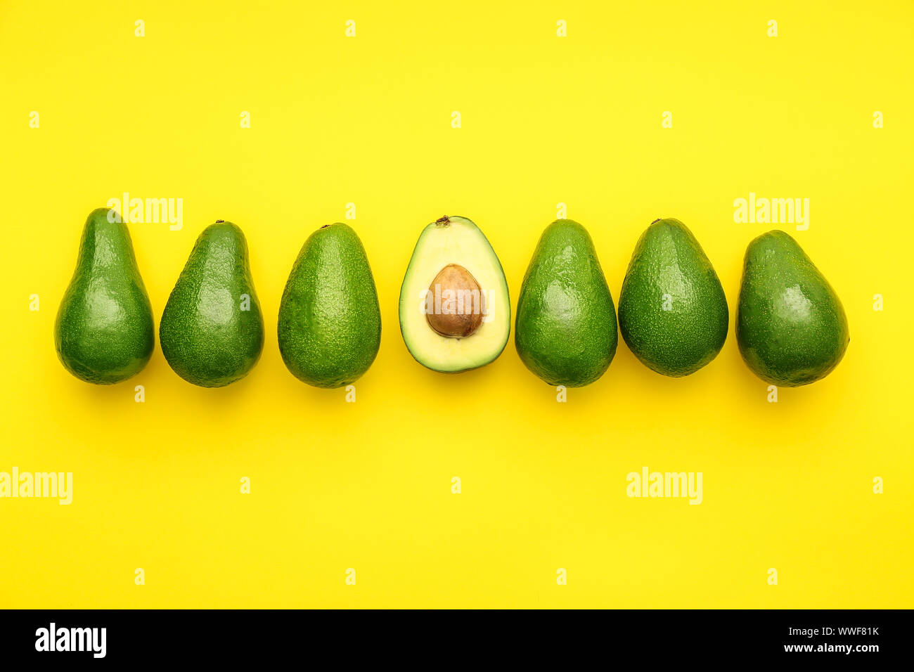 Whole avocados and one half on color background. Concept of uniqueness ...