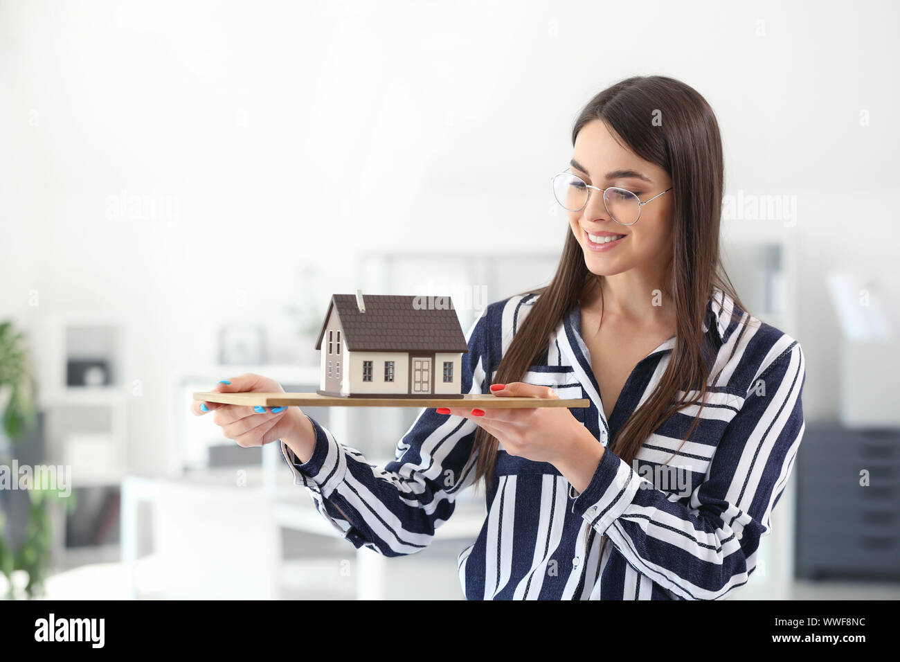 Beautiful female architect with model of house in office Stock Photo ...