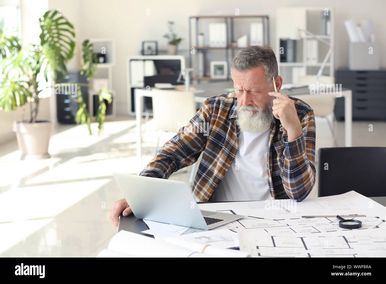 Mature male architect working in office Stock Photo - Alamy
