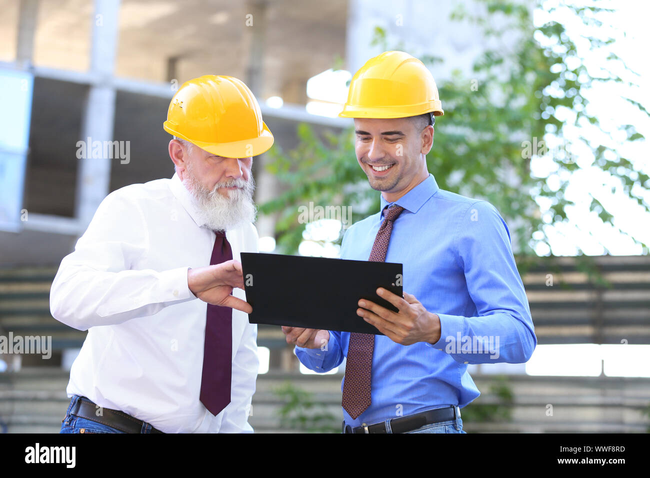 Architects discussing project of building outdoors Stock Photo - Alamy