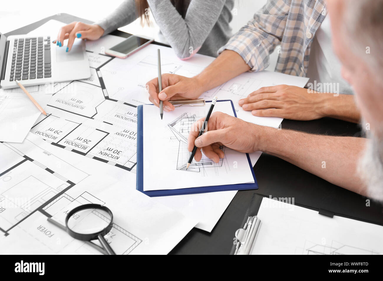 Team of architects discussing project in office Stock Photo - Alamy