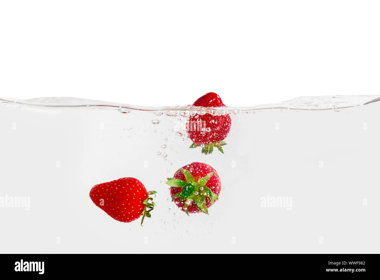 Falling of sweet strawberry in water against white background Stock ...