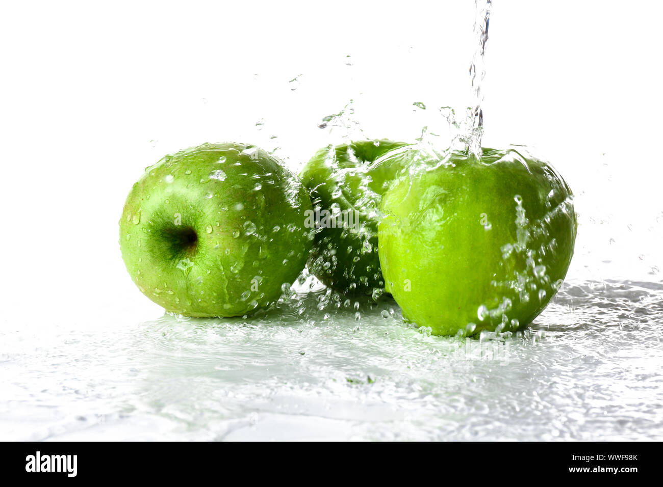 Pouring of water on apples against white background Stock Photo - Alamy