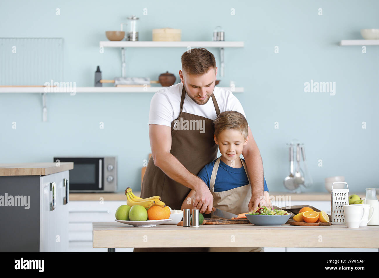 Portrait of happy father and son cooking in kitchen Stock Photo - Alamy