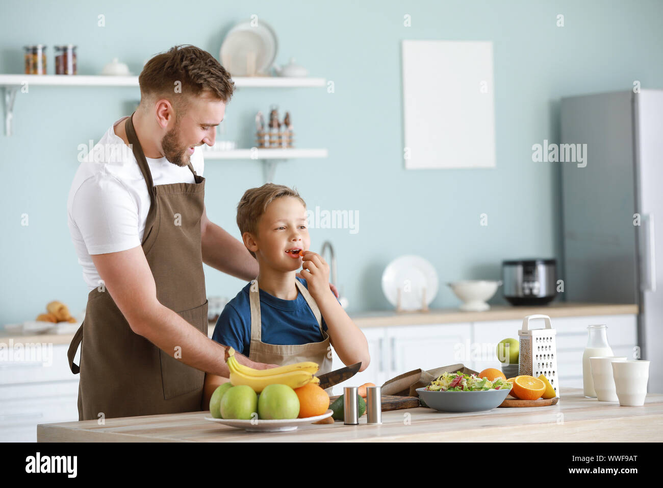 Portrait of happy father and son cooking in kitchen Stock Photo - Alamy