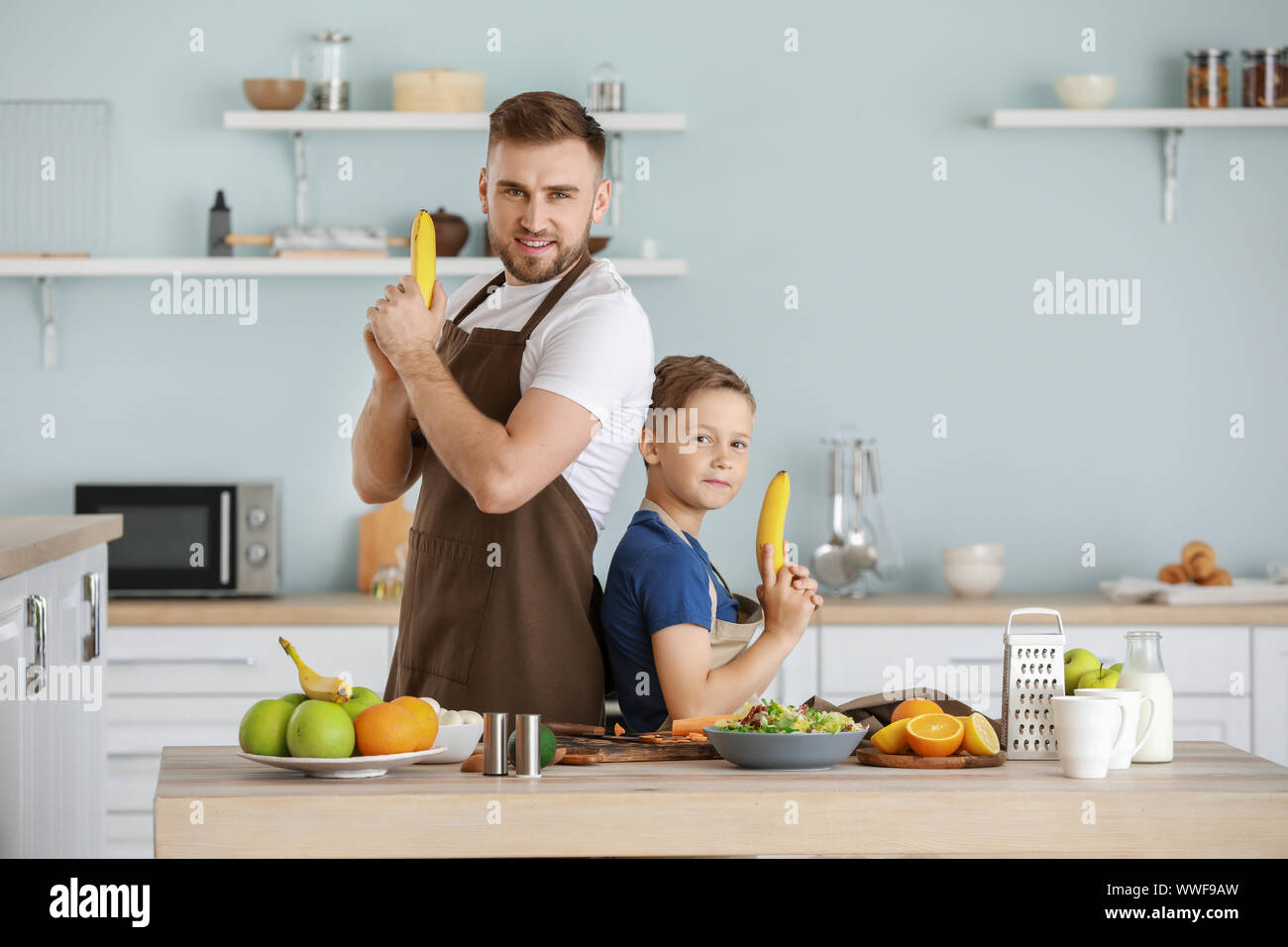 Portrait of father and son having fun while cooking in kitchen Stock ...