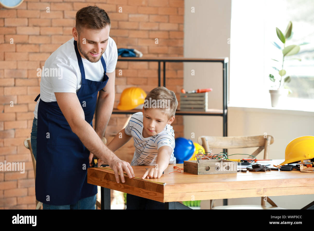 Father teaching his little son to handle with tools at home Stock Photo ...