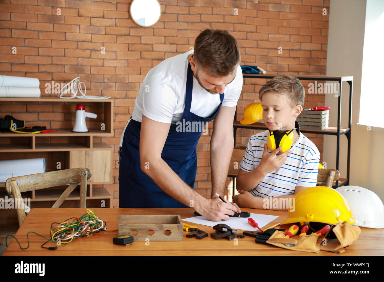 Father teaching his little son to handle with tools at home Stock Photo ...