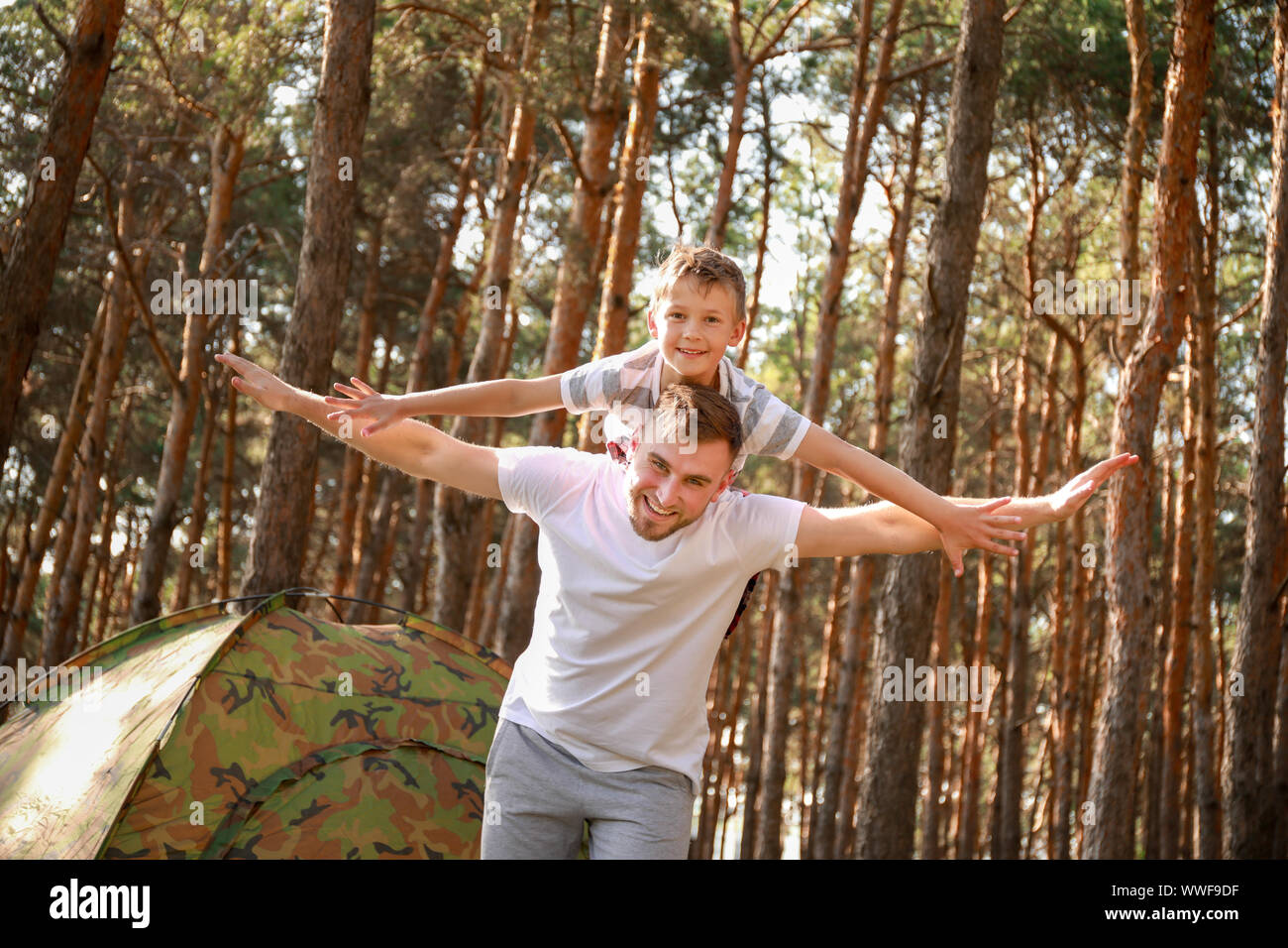 Portrait of happy father and son in forest Stock Photo - Alamy