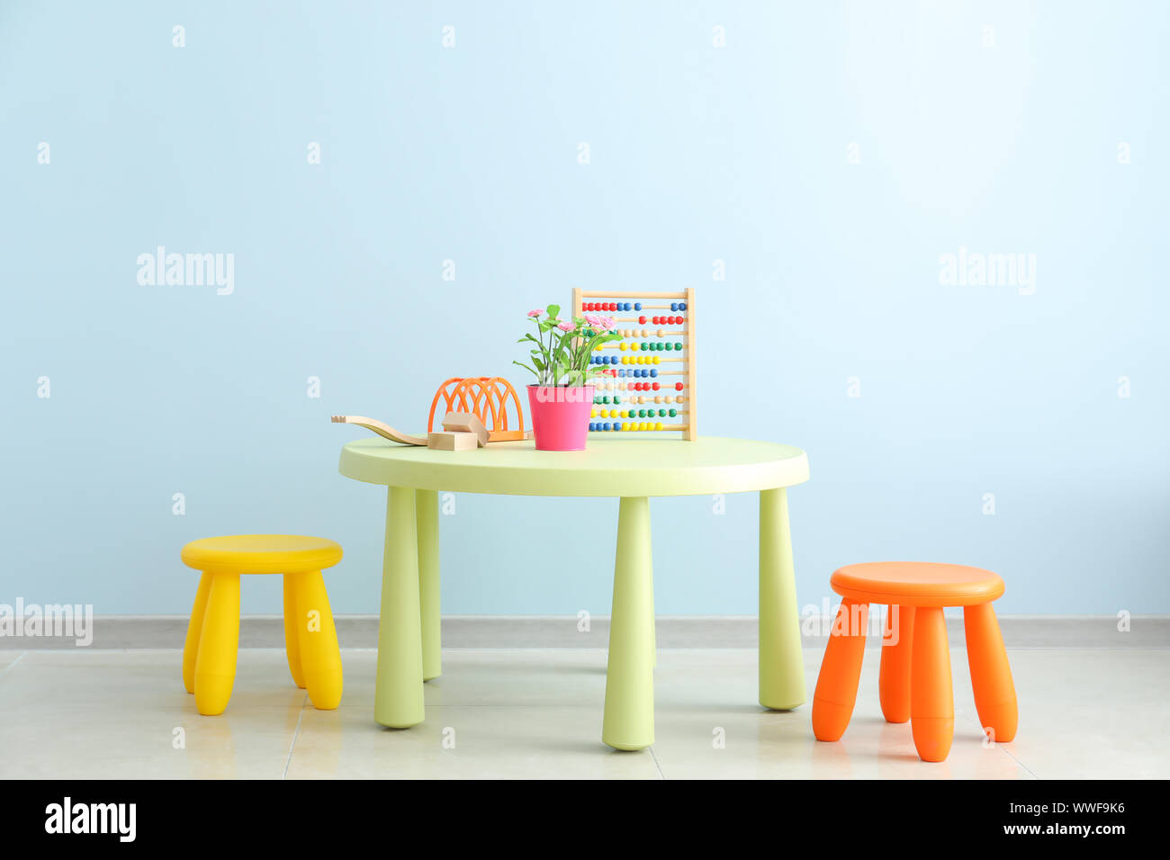 Table and stools near wall in modern children's room Stock Photo - Alamy