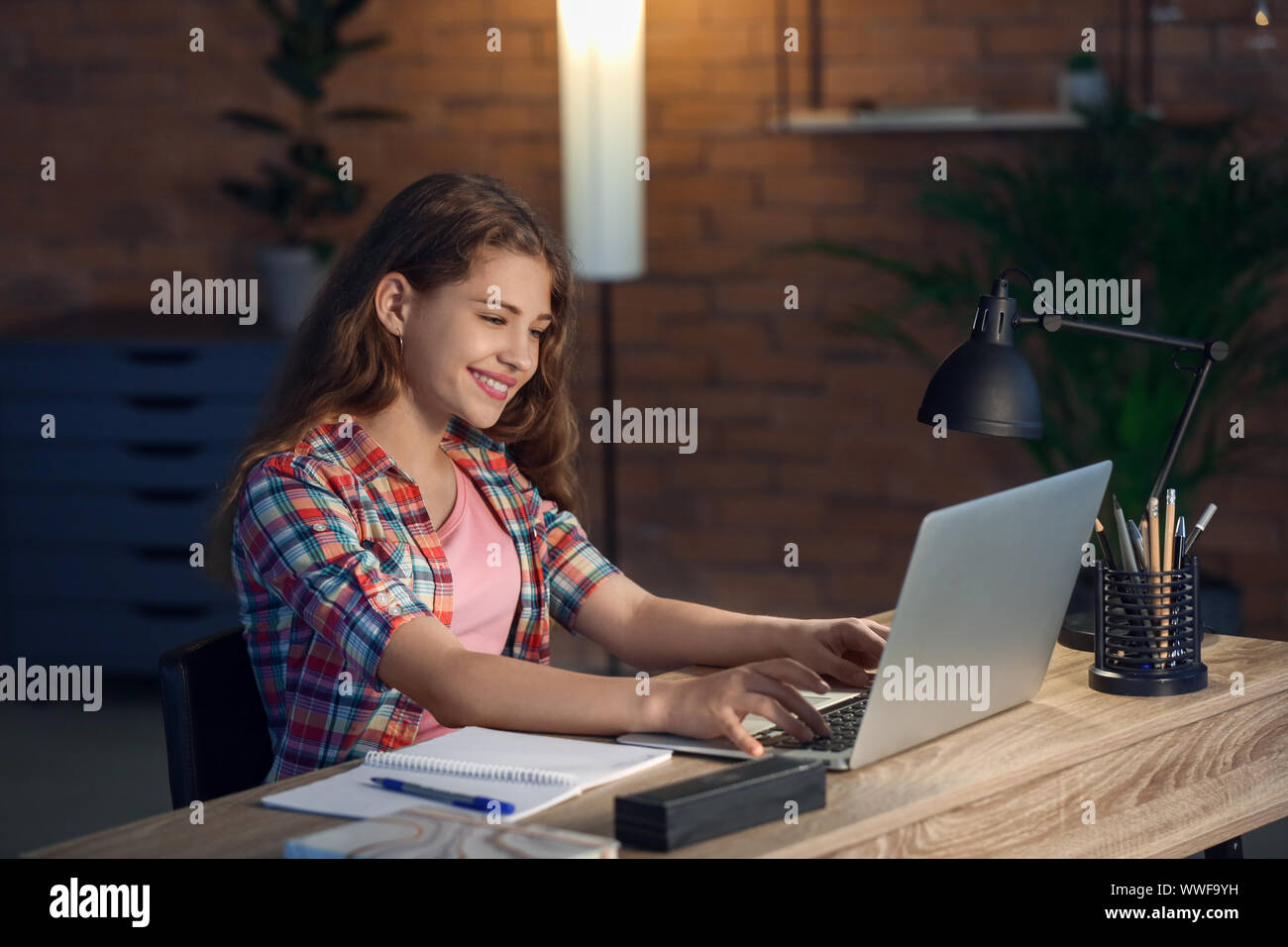 Teenage girl doing homework late in evening Stock Photo - Alamy