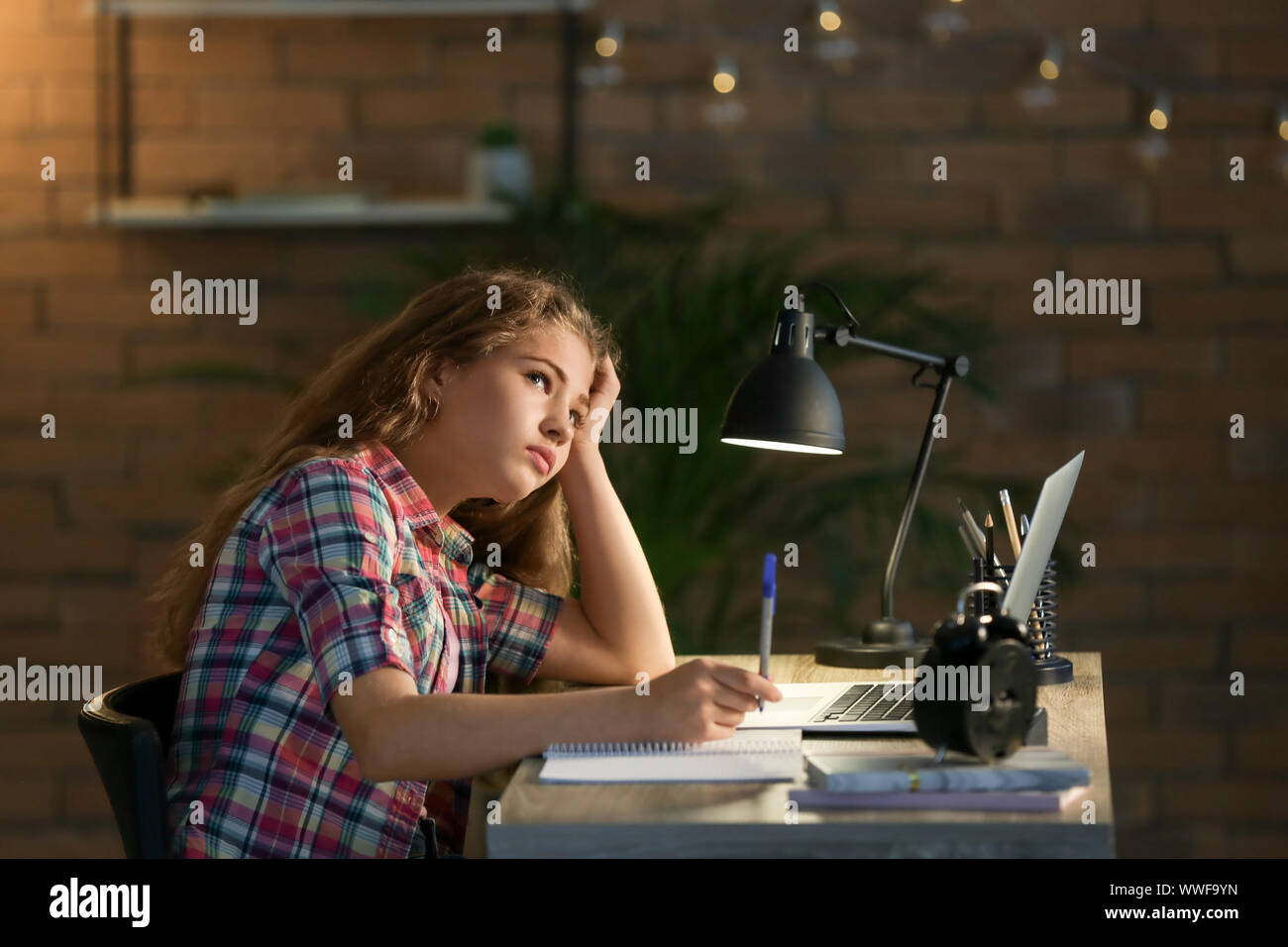 Tired teenage girl doing homework late in evening Stock Photo - Alamy