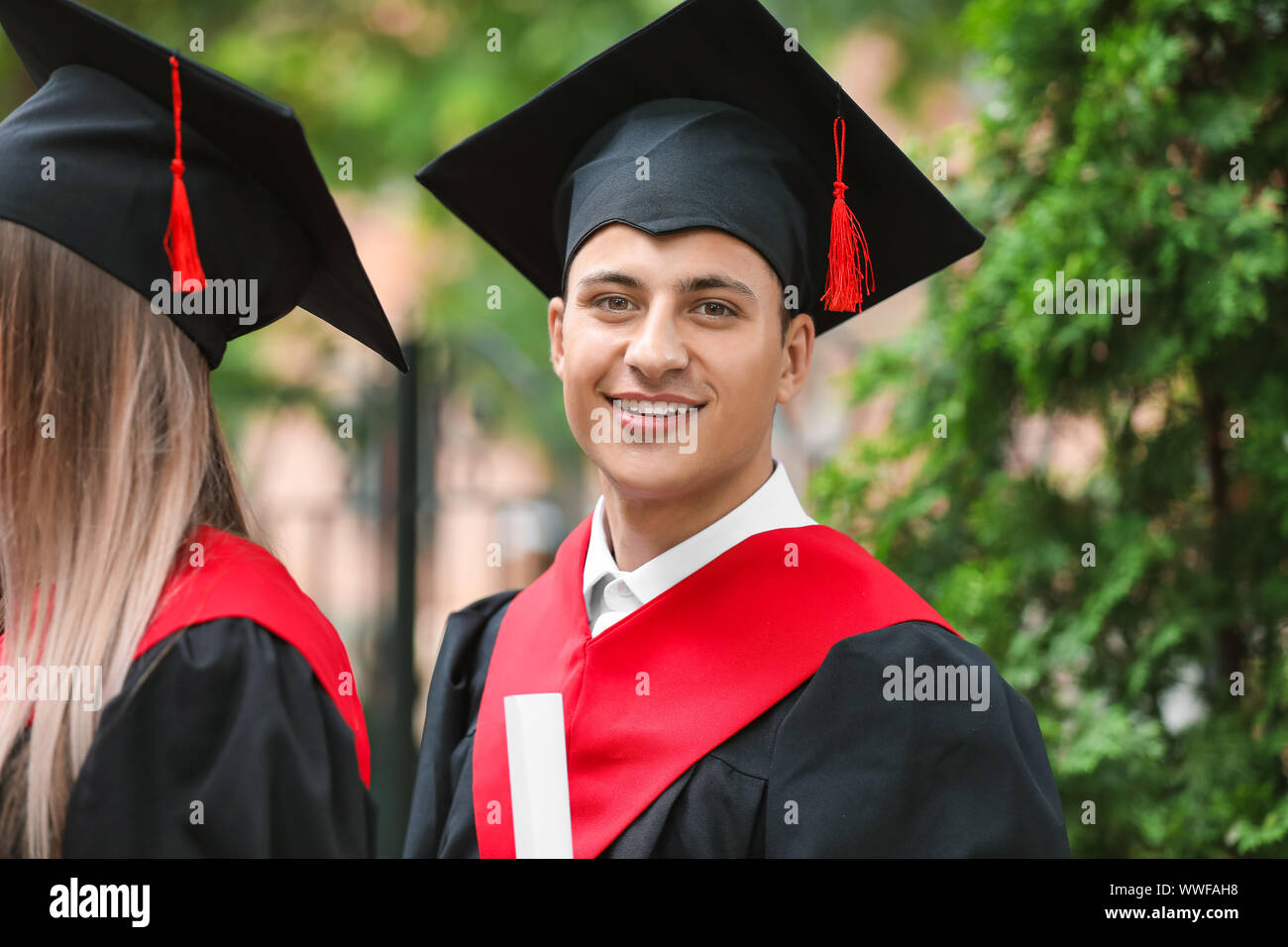 Happy students in bachelor robes outdoors Stock Photo - Alamy