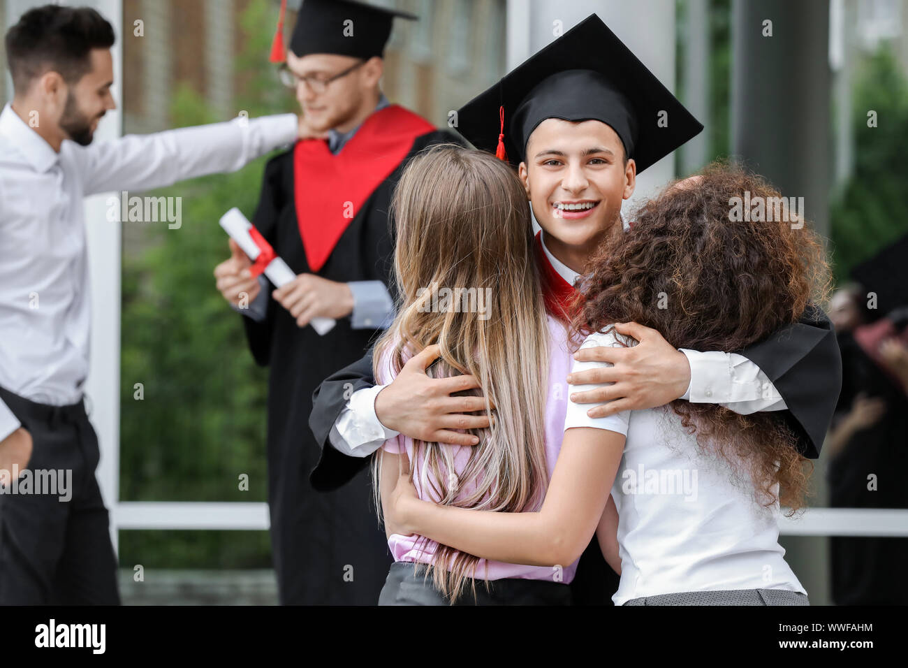 Friends greeting young man on his graduation day Stock Photo - Alamy