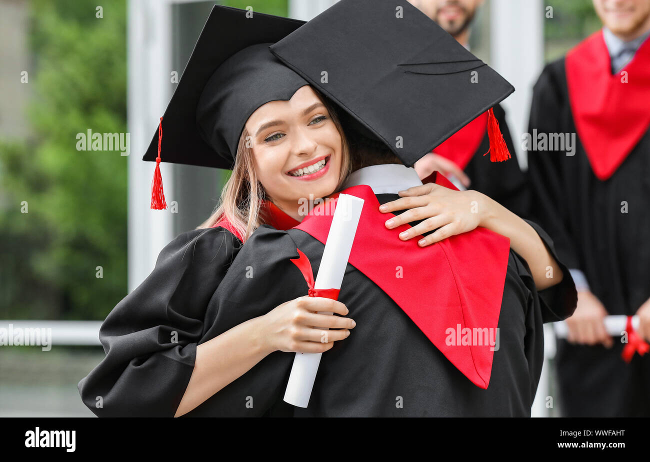 Happy students in bachelor robes hugging outdoors Stock Photo - Alamy