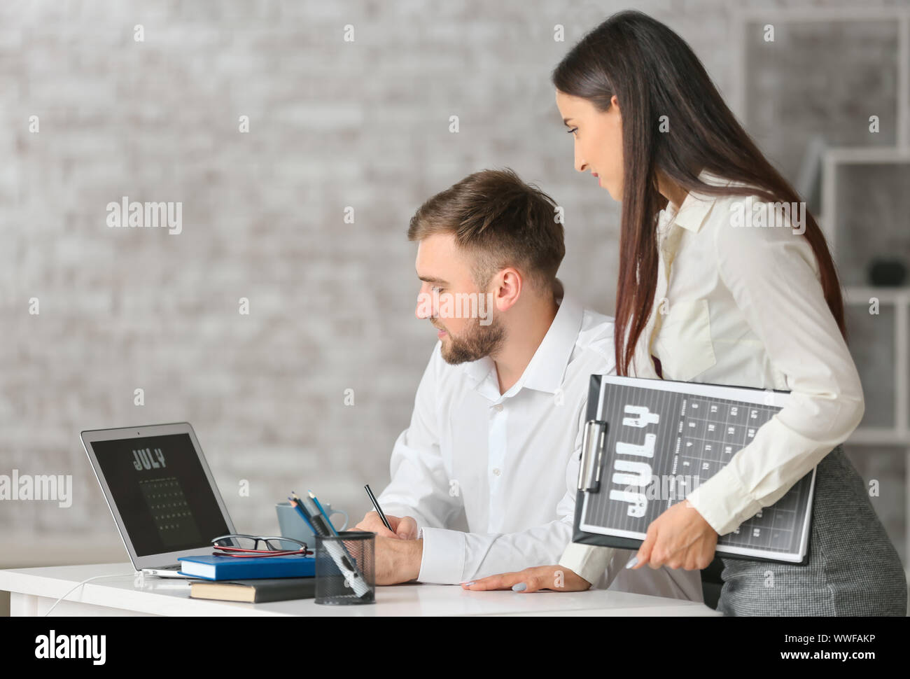 Office workers using calendar on laptop screen during work Stock Photo ...
