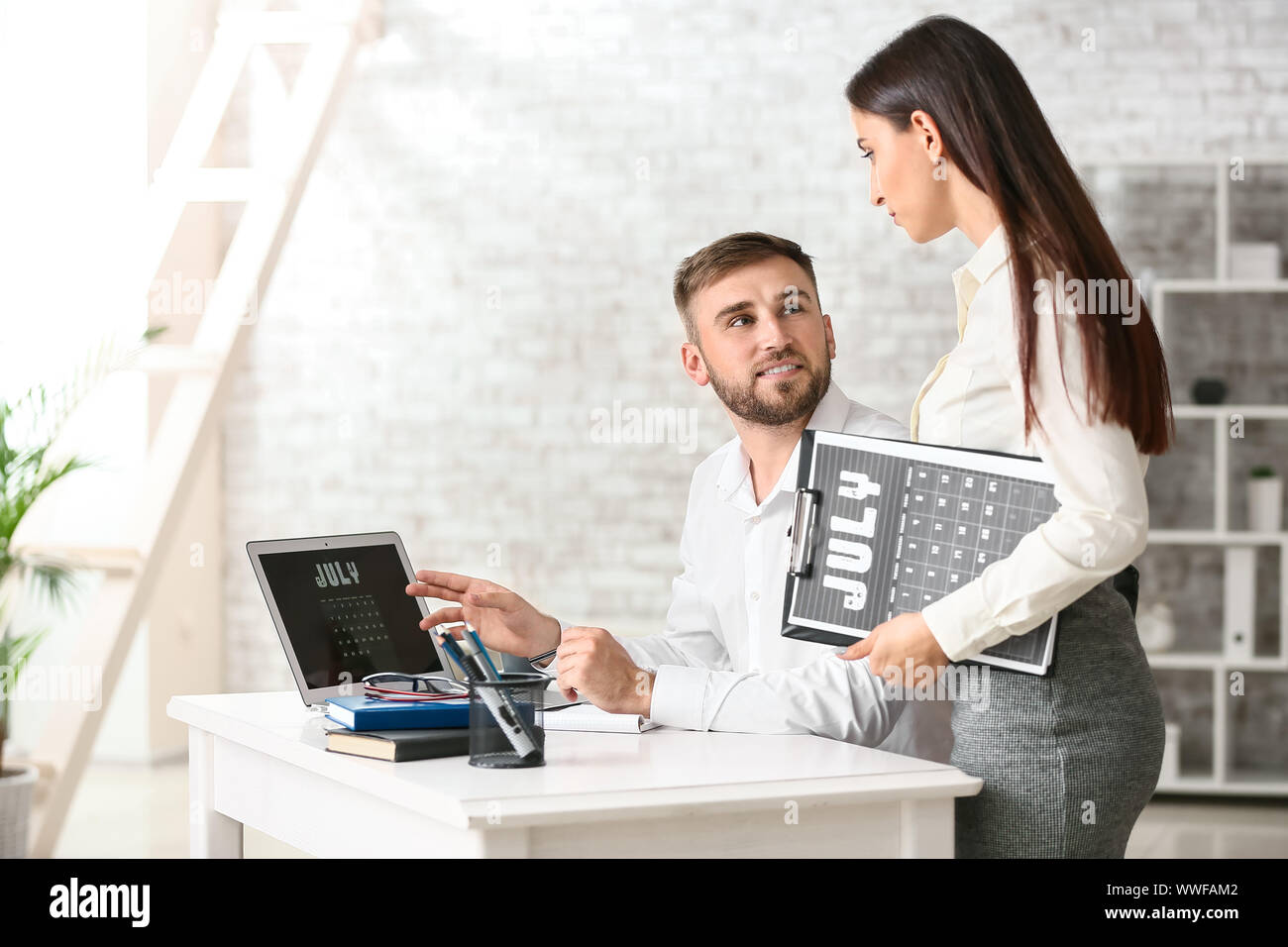 Office workers using calendar on laptop screen during work Stock Photo ...