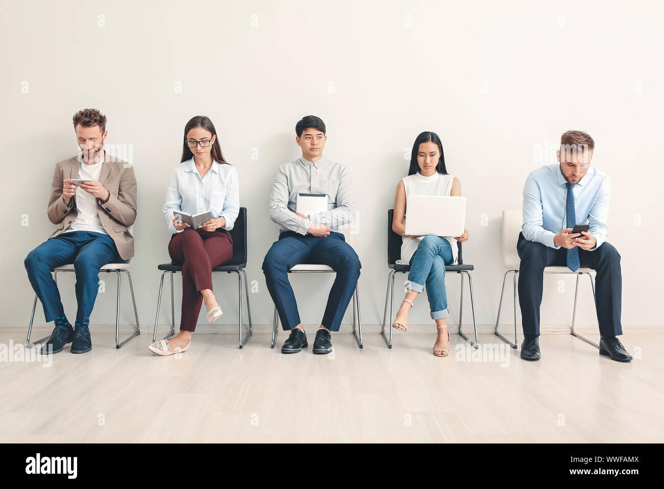 Young people waiting for job interview indoors Stock Photo - Alamy