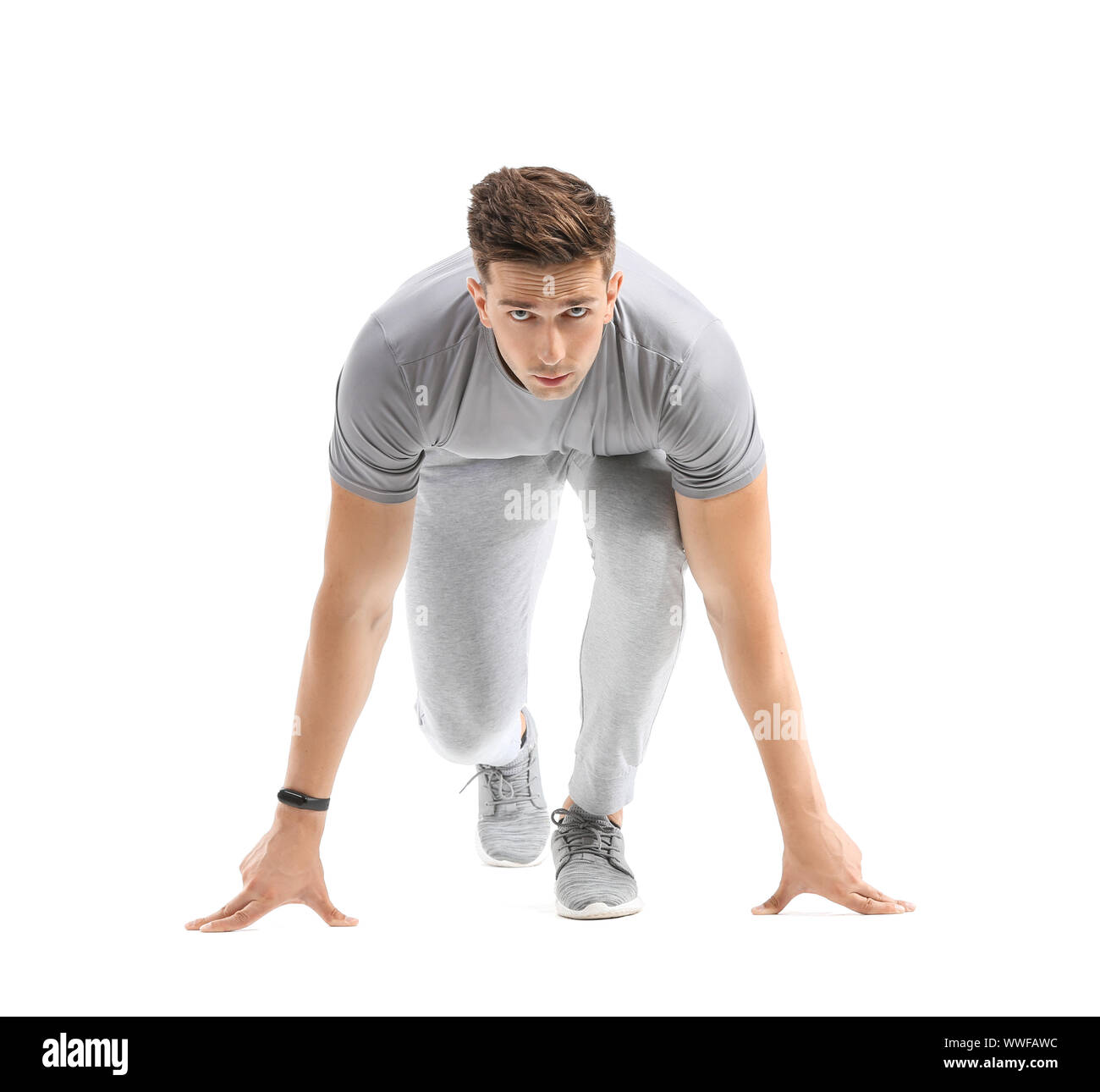 Sporty young man in crouch start position on white background Stock ...