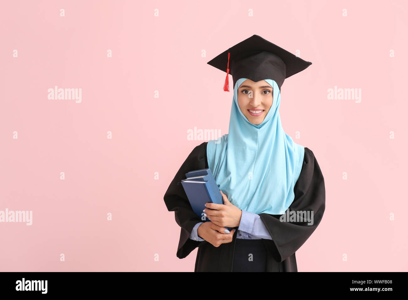 Muslim female graduate on color background Stock Photo - Alamy
