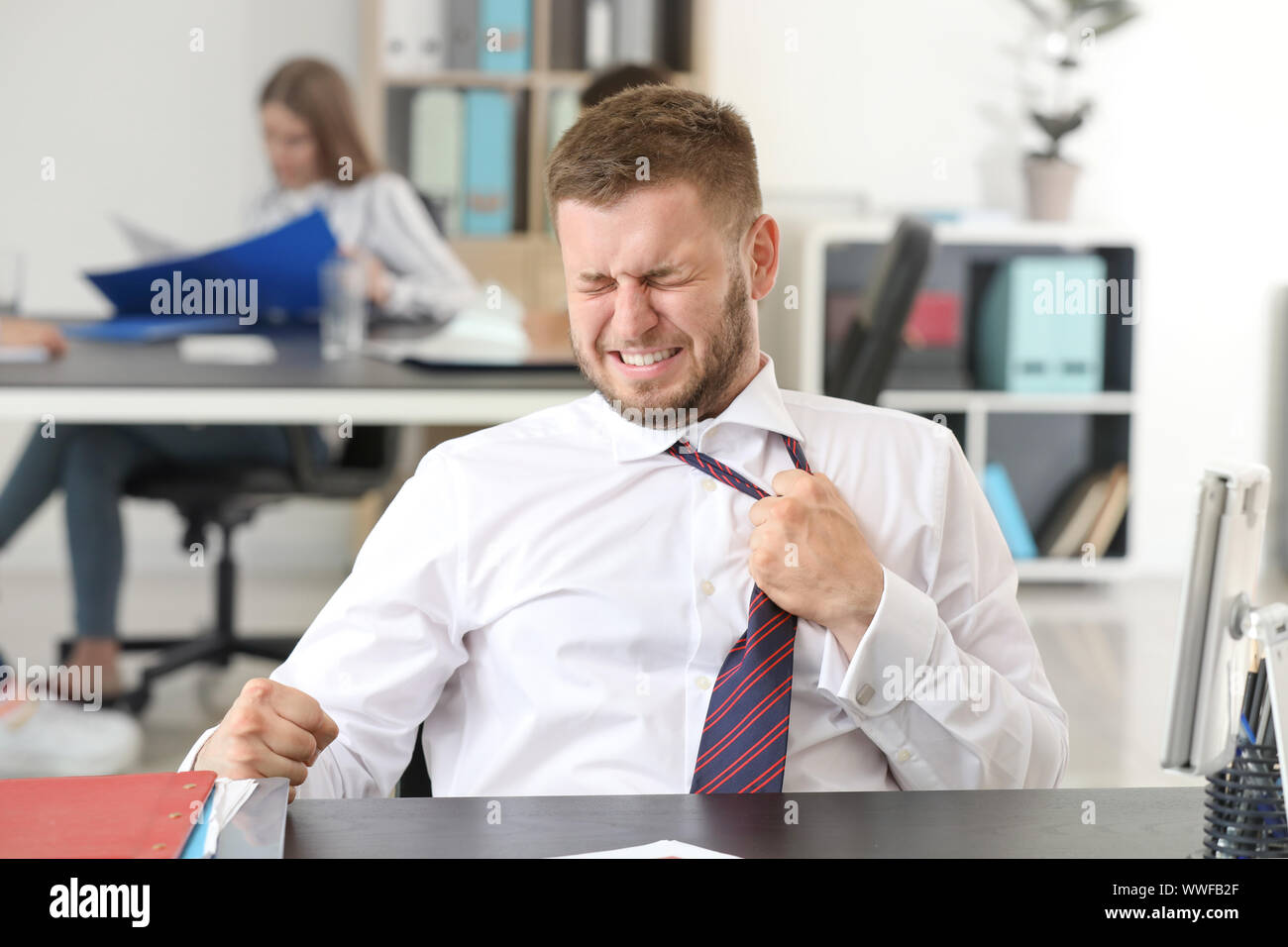Businessman having panic attack in office Stock Photo - Alamy