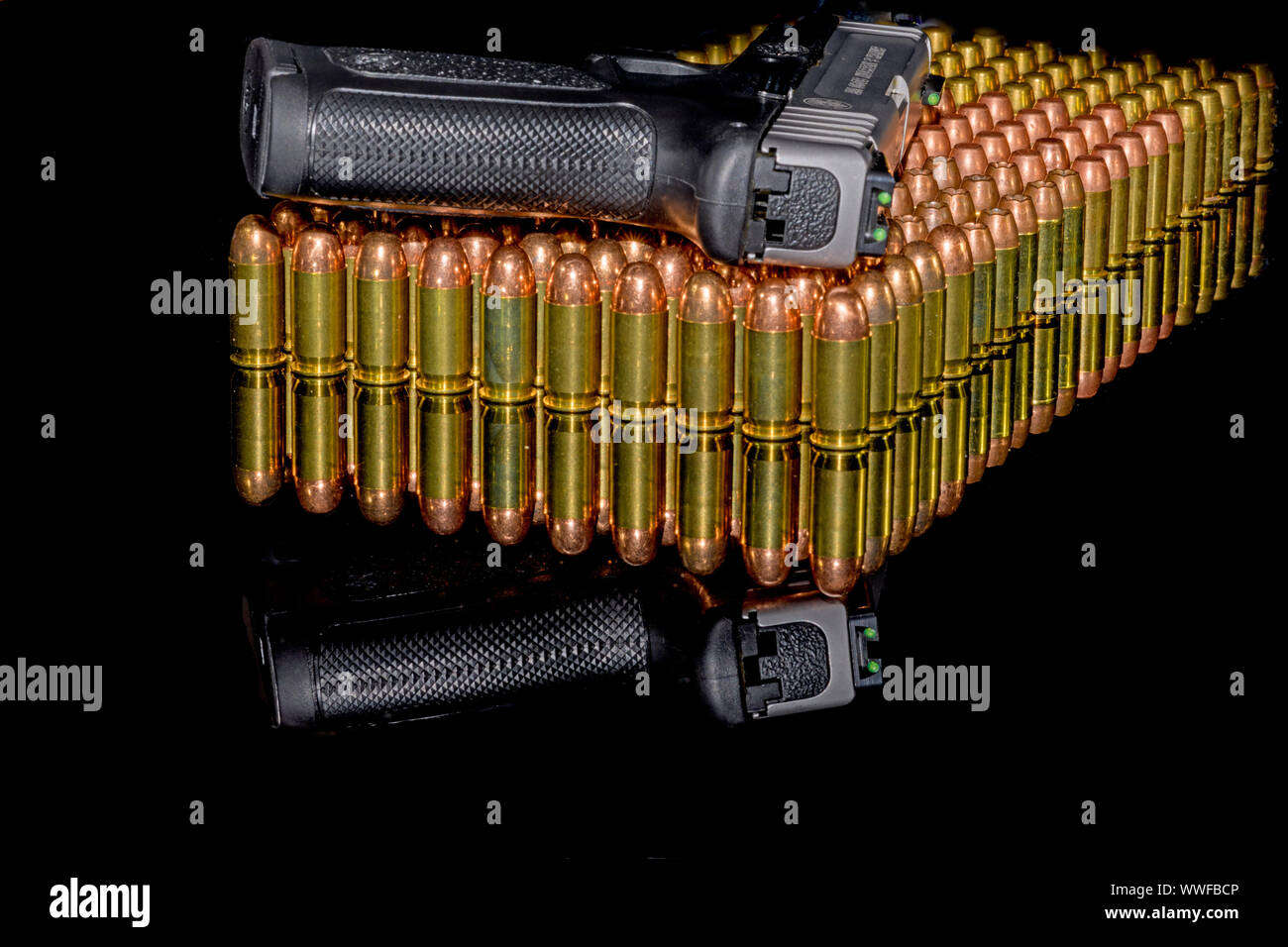 Semi-Automatic Handgun on rows of ammo, ammunition with black ...
