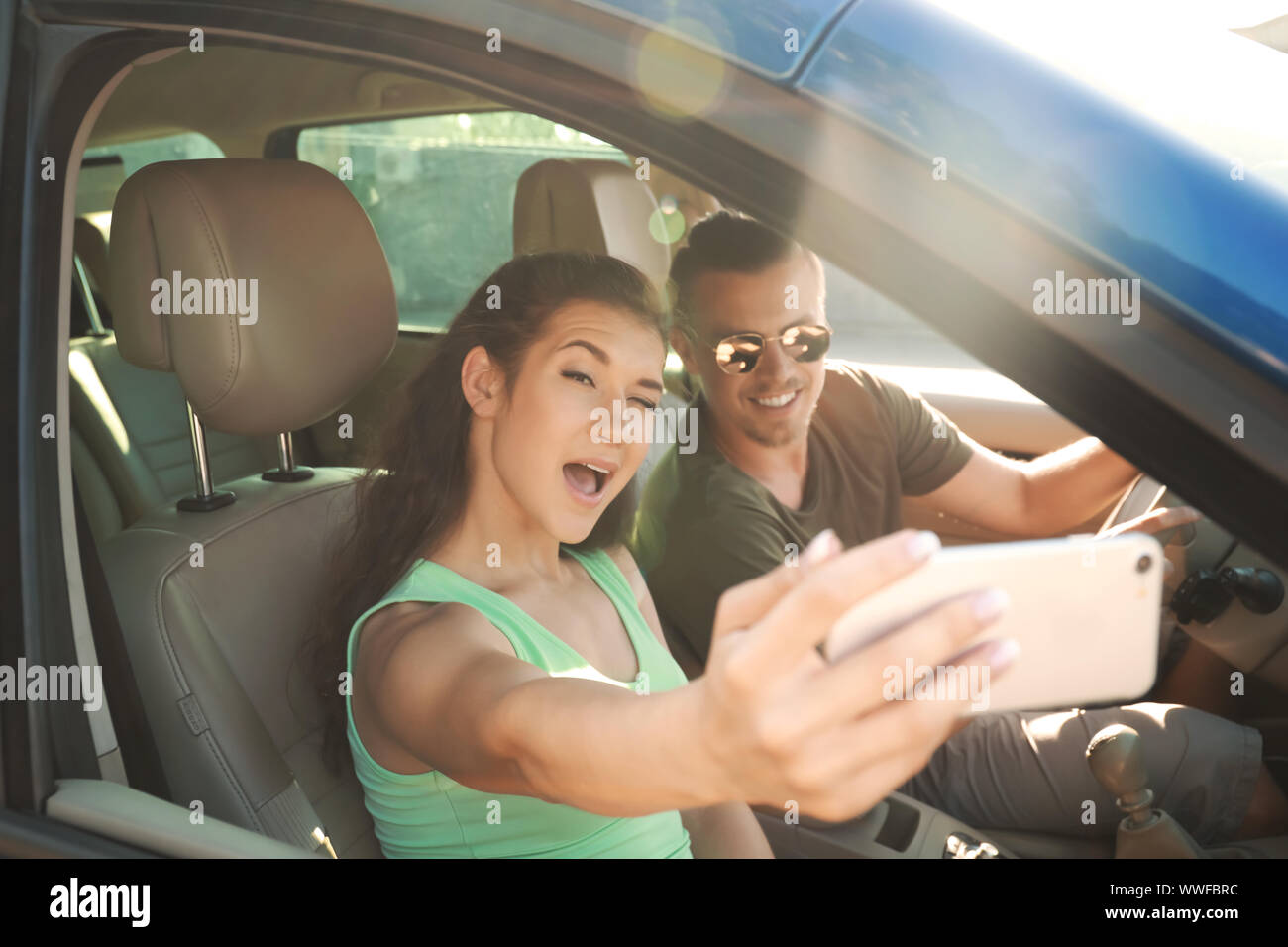 Happy young couple taking selfie in car Stock Photo - Alamy