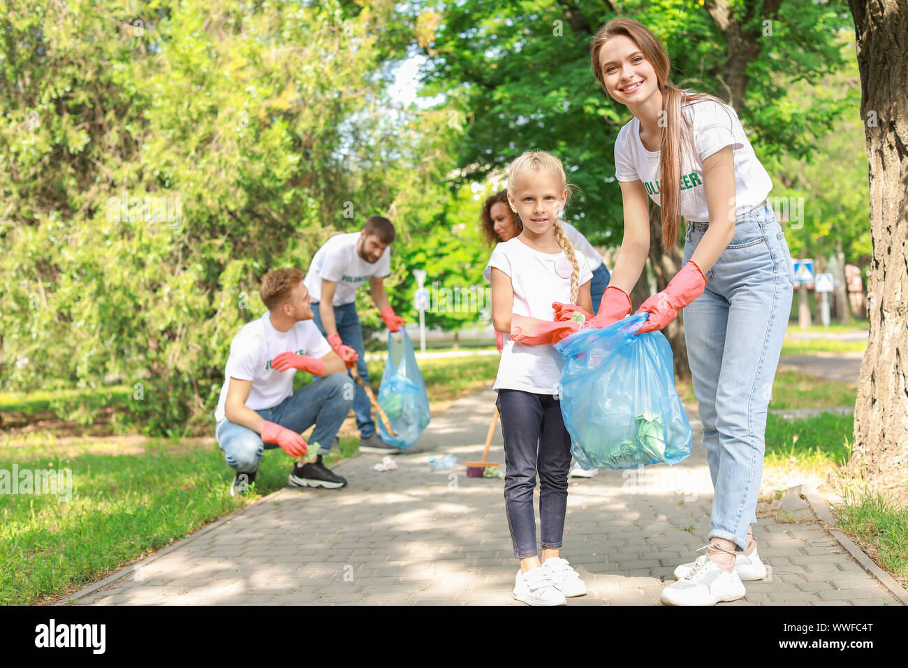Volunteers gathering garbage in park Stock Photo - Alamy
